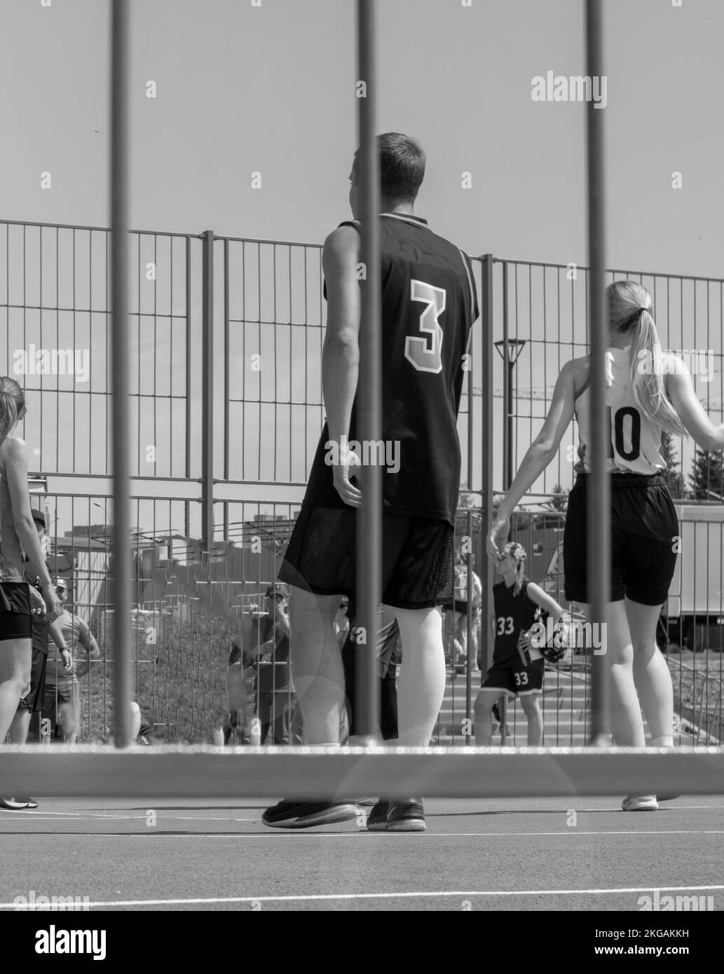 A team of students plays basketball on a sports field on campus ...