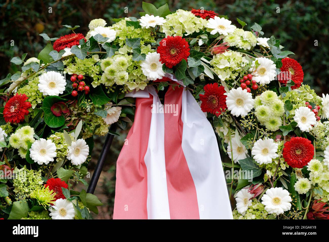 funeral wreath in a cemetery with colorful flowers and red and white ...