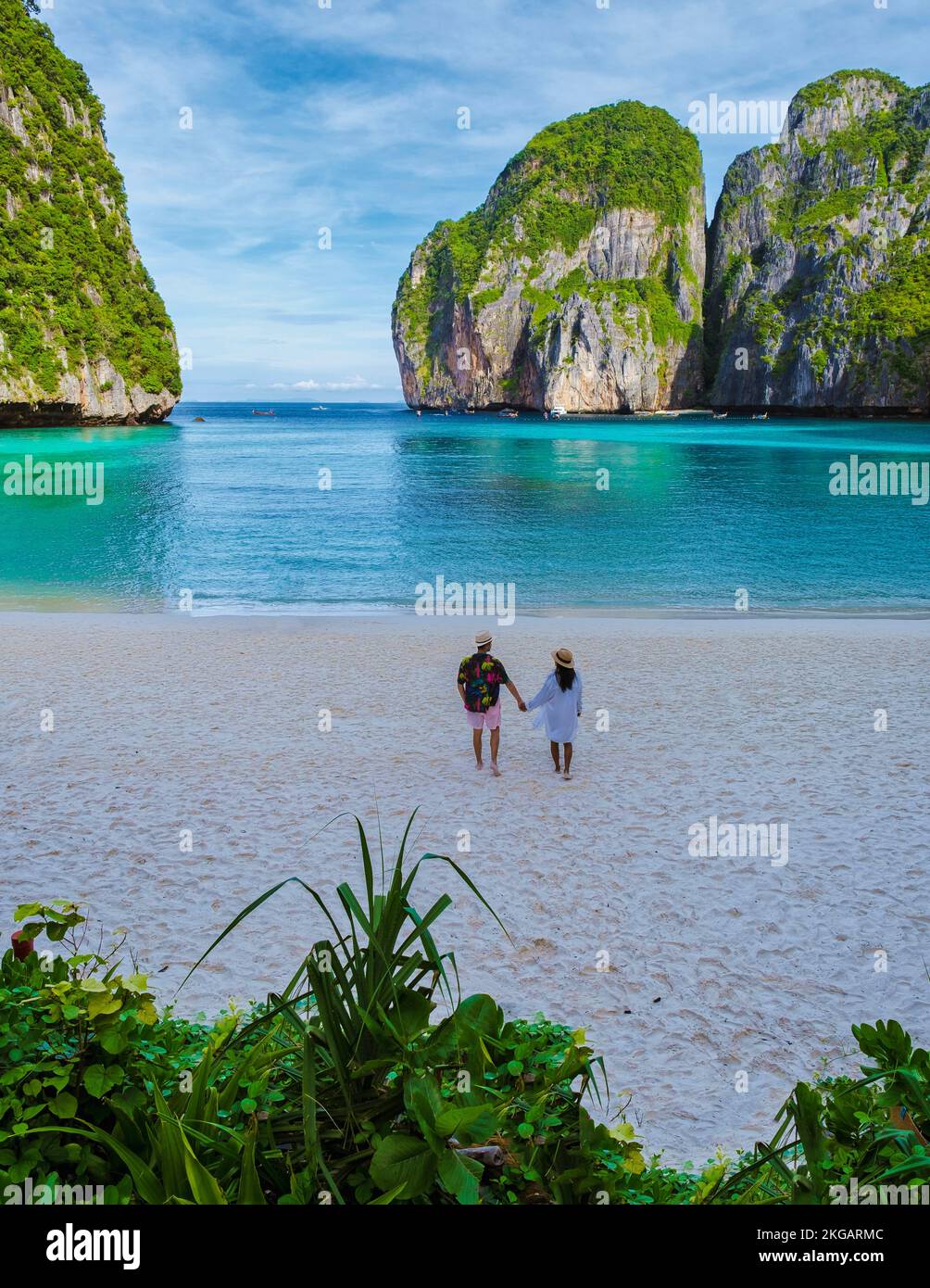 Thai women and caucasian men walk on the beach of Maya Bay beach Koh ...