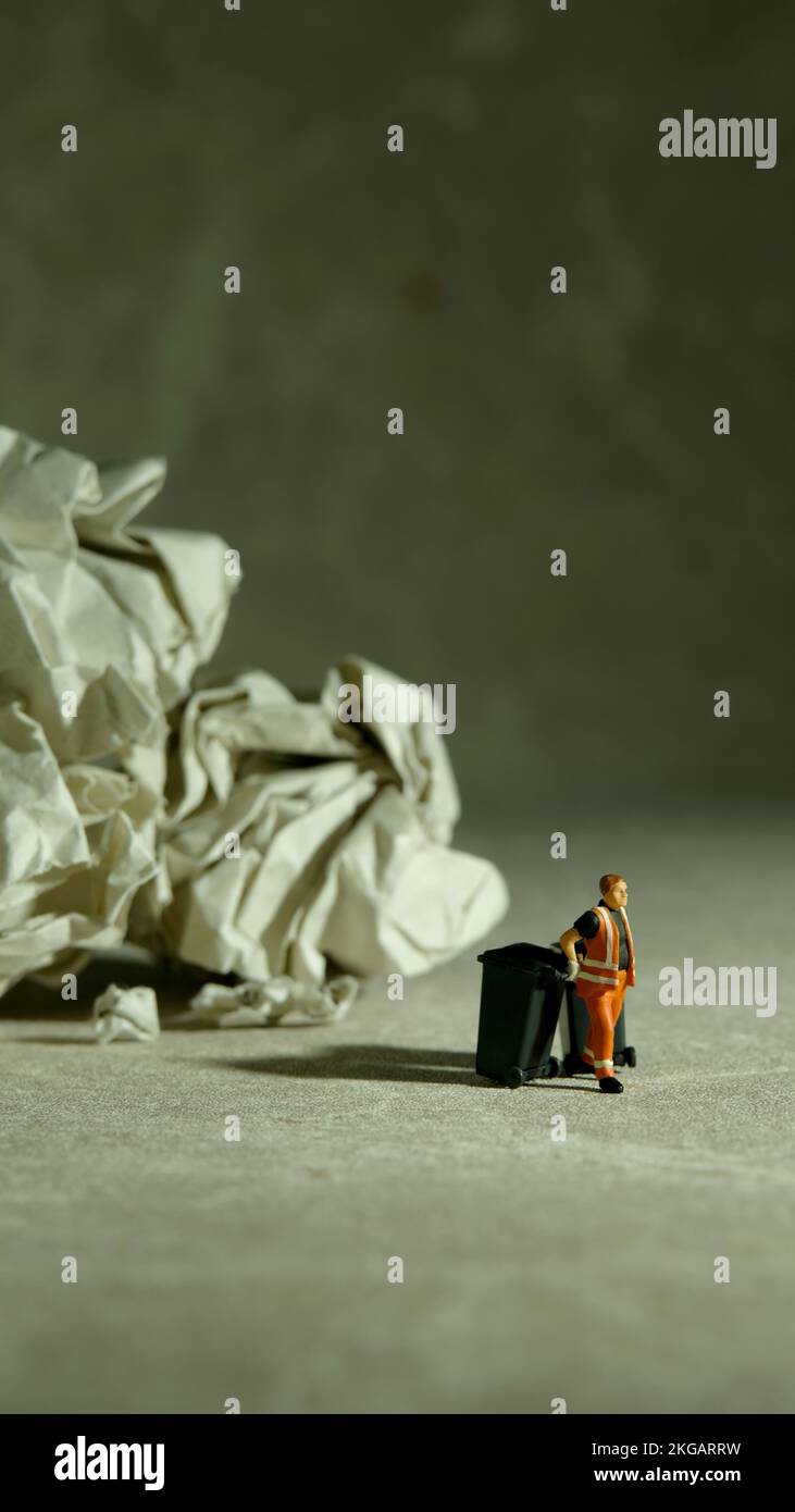 Miniature people toy figure photography. Cleaning worker with trash bin ...
