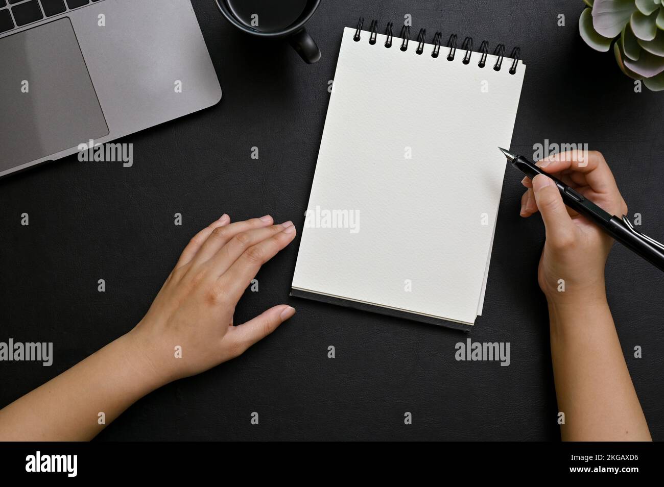 Top view, A female hand holding pen, taking notes on spiral notepad in ...