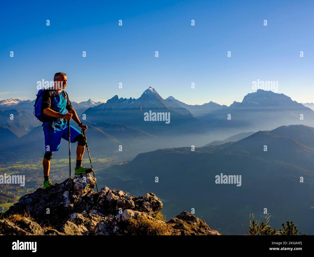 Mountaineer at the summit Rauher Kopf looking at the Berchtesgaden Alps ...