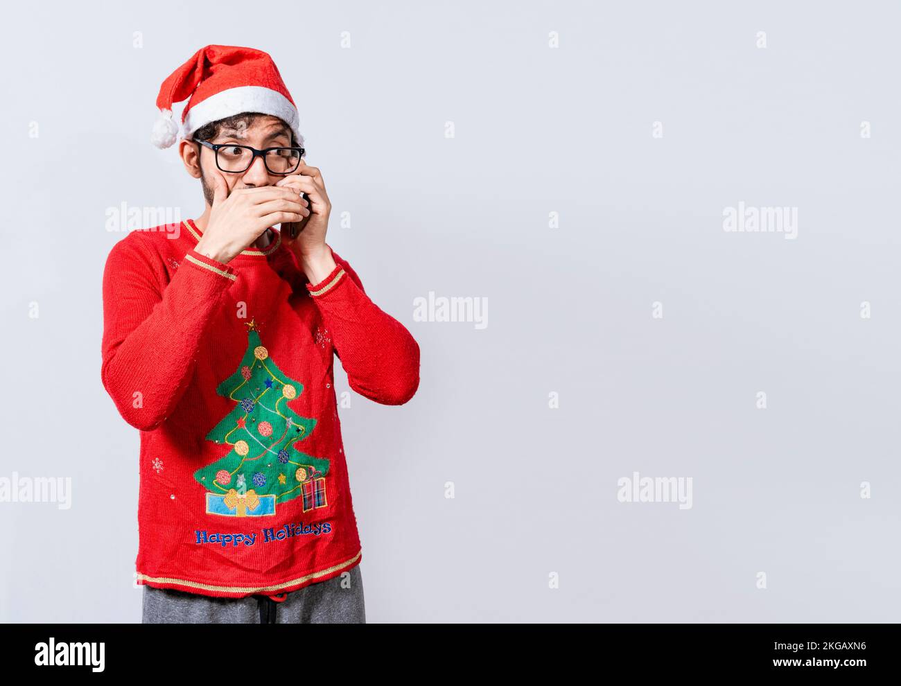 Man in christmas hat talking on the phone secretly. Christmas guy ...