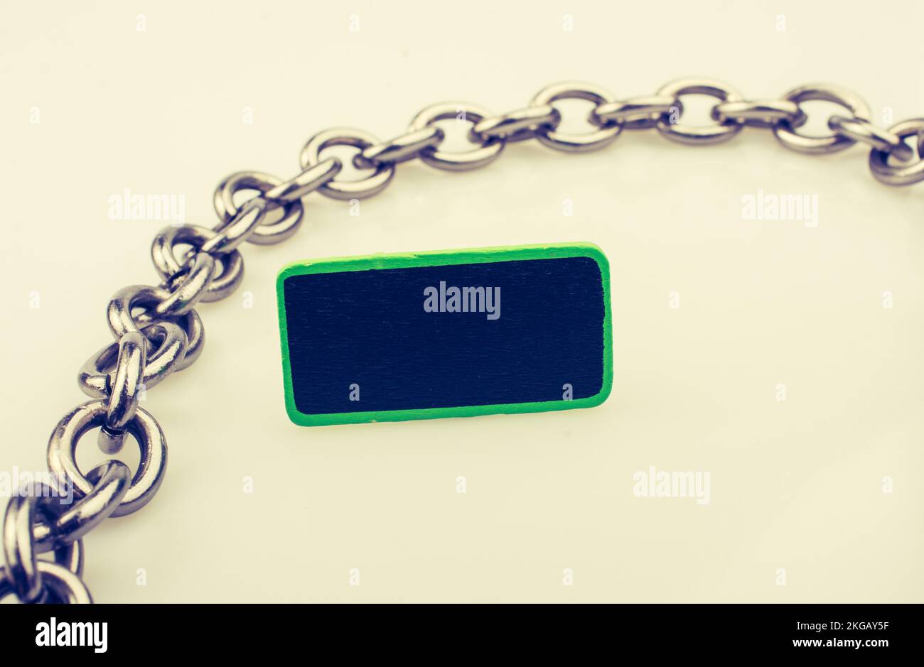 Small green sided black noticeboard surrounded by chain on a white ...