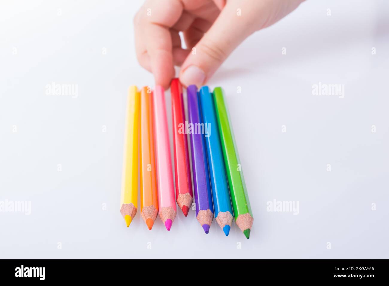 Hand holding color Pencils placed on a white background Stock Photo - Alamy
