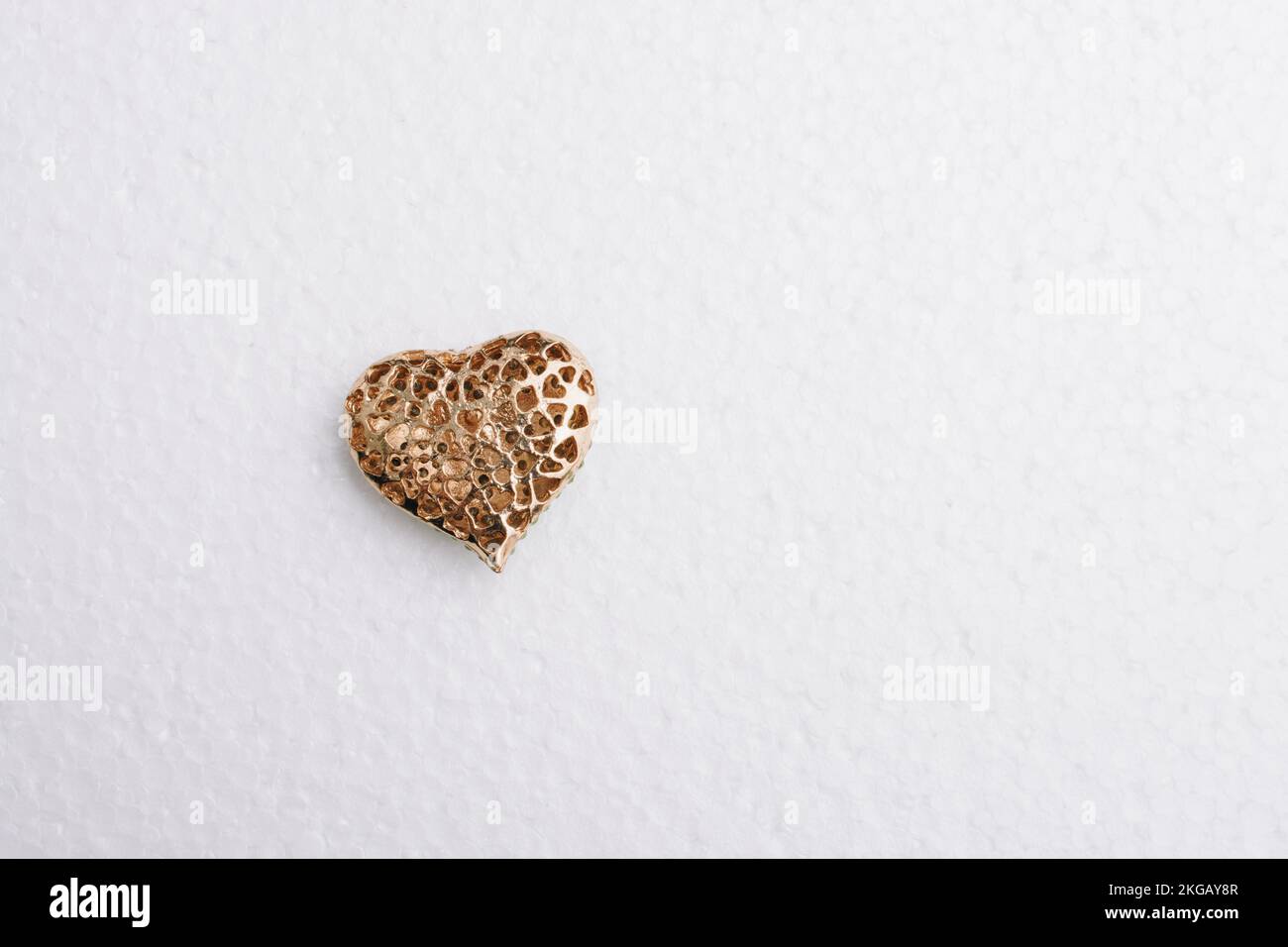 Gold color heart shaped l decorative object in view Stock Photo - Alamy