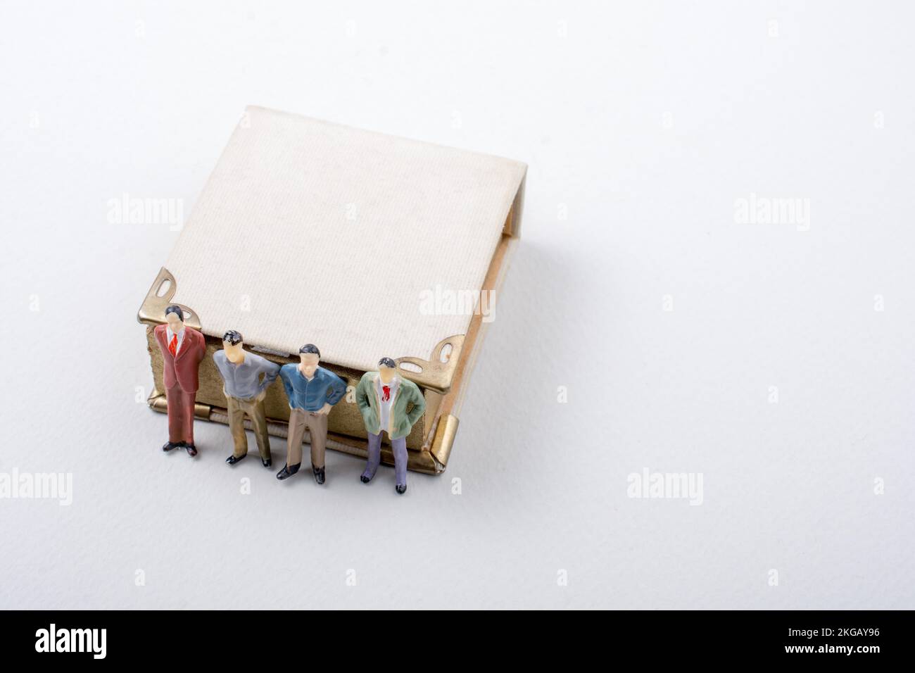 Tiny figurine of men models found beside a book Stock Photo - Alamy