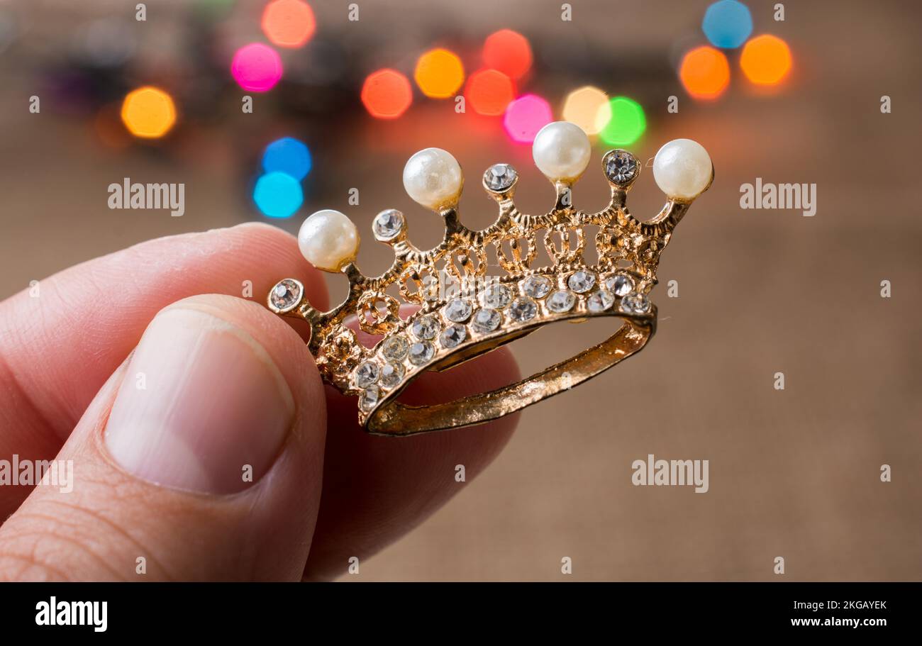 Hand holding a little model crown in hand Stock Photo - Alamy