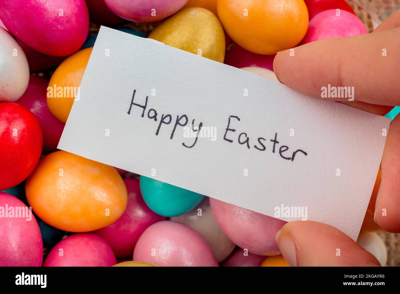 Happy Easter written on a small piece of paper on colorful decorative ...
