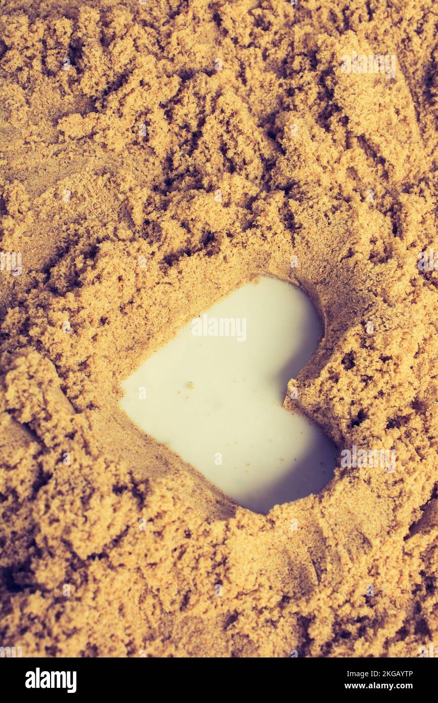 Heart shape made on the sand background in view Stock Photo - Alamy