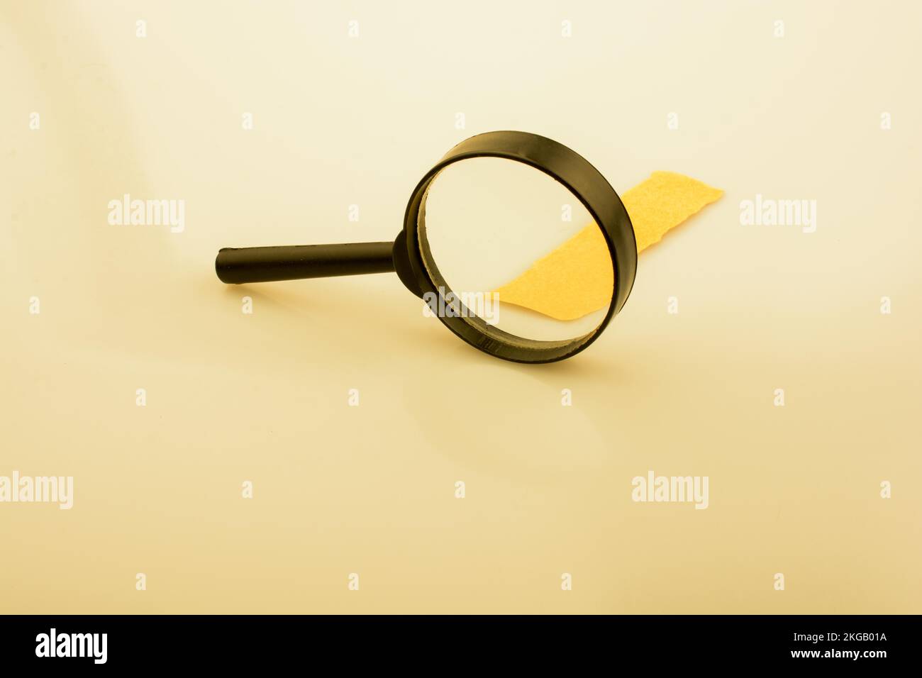 Piece of torn paper placed under magnifying glass Stock Photo - Alamy