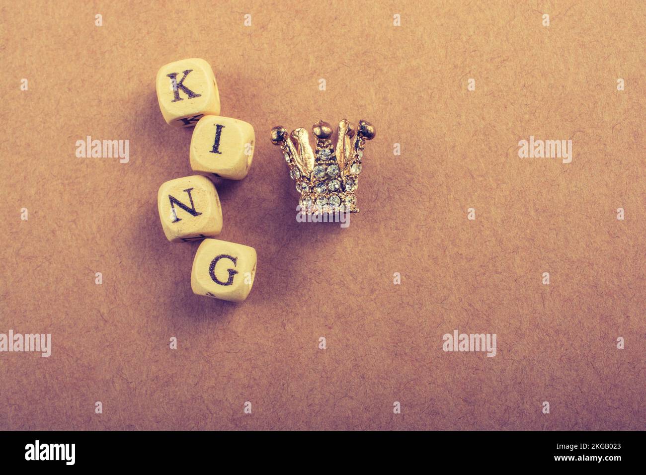 Tiny model crown beside the king wording on brown Stock Photo - Alamy