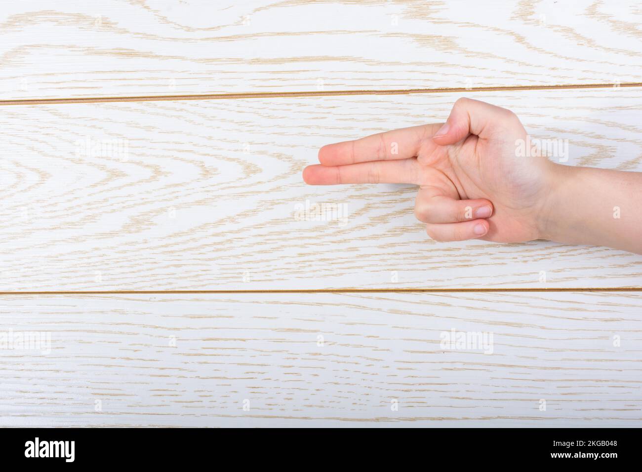 Hand making a gesture on a wooden background Stock Photo - Alamy