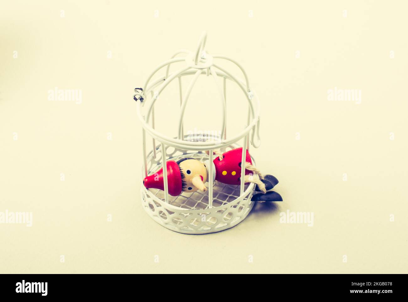 Metal cage and Little puppet pinocchio made of wood Stock Photo - Alamy