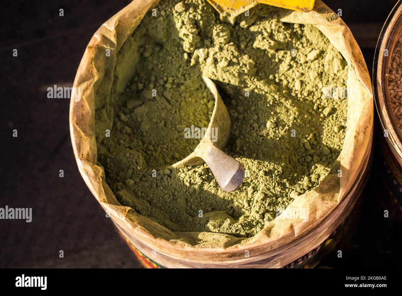 Dry henna in a bucket with a wooden shovel in it Stock Photo - Alamy