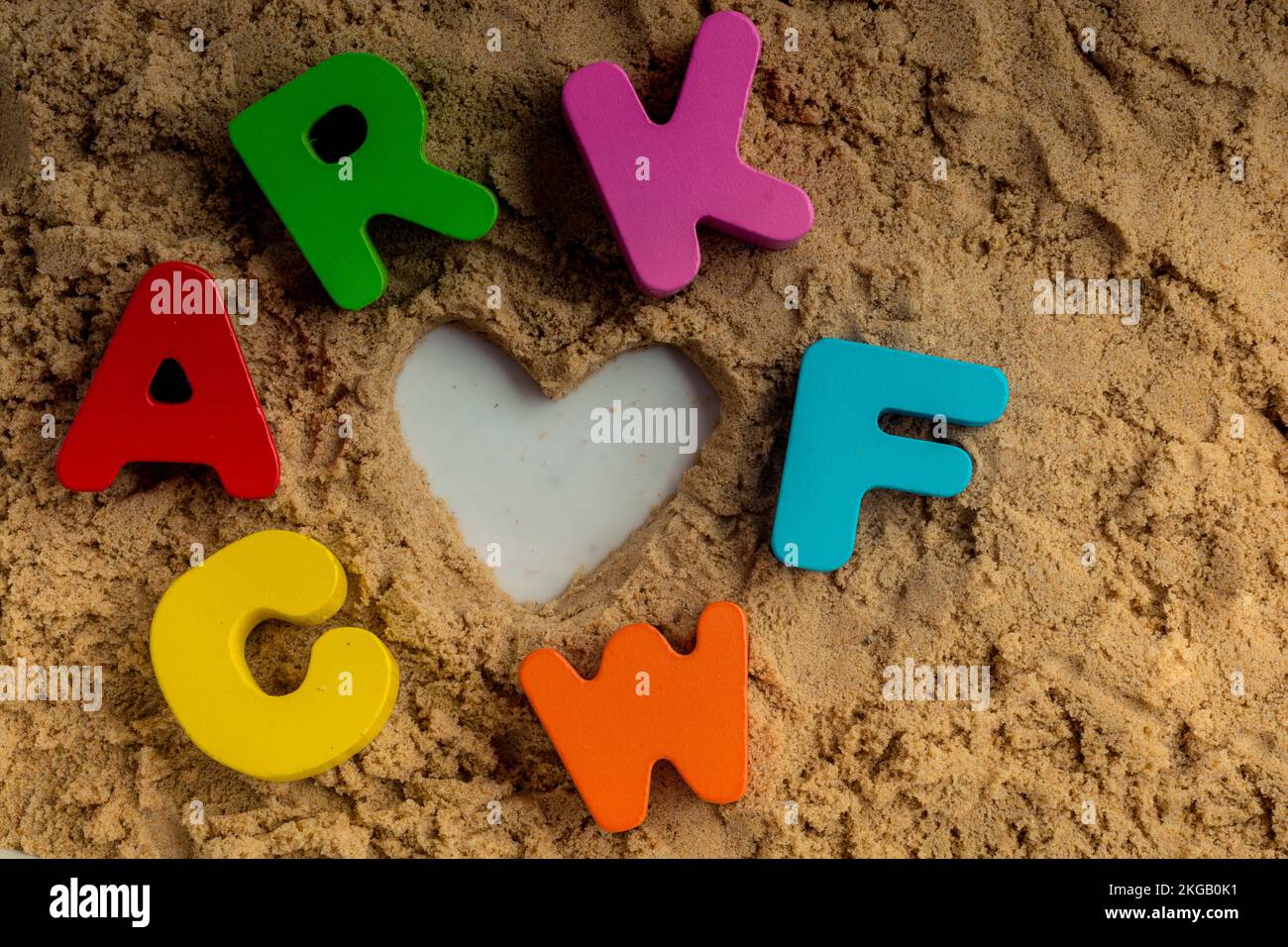 Heart shape and colorful Letters made of wood on sand Stock Photo - Alamy