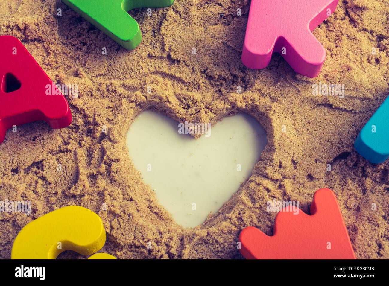 Heart shape and colorful Letters made of wood on sand Stock Photo - Alamy
