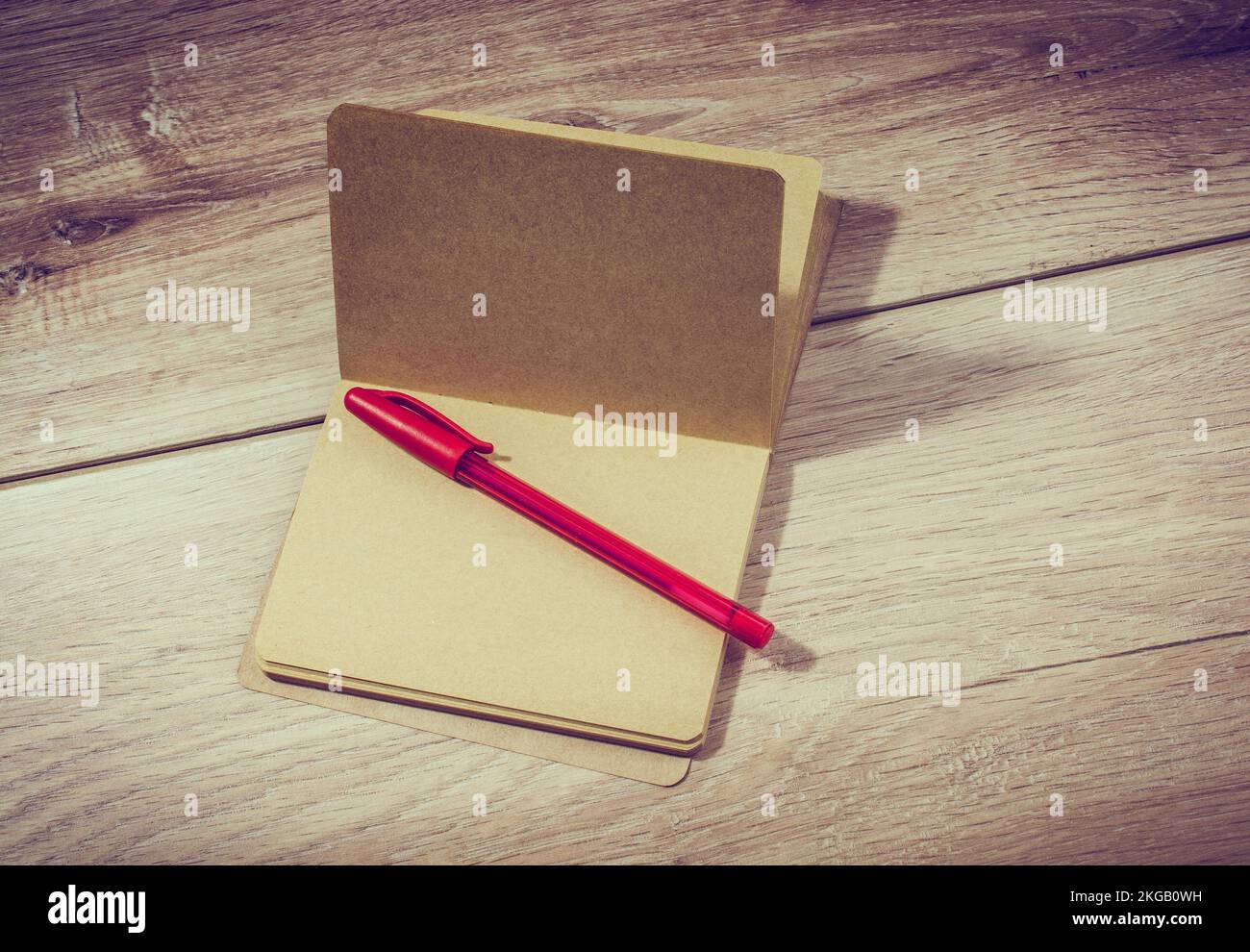 Brown color open notebook and a pen on wooden texture Stock Photo - Alamy
