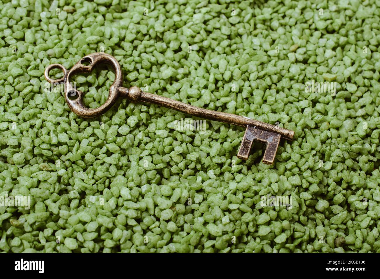 Retro style gold color key on green sand Stock Photo - Alamy