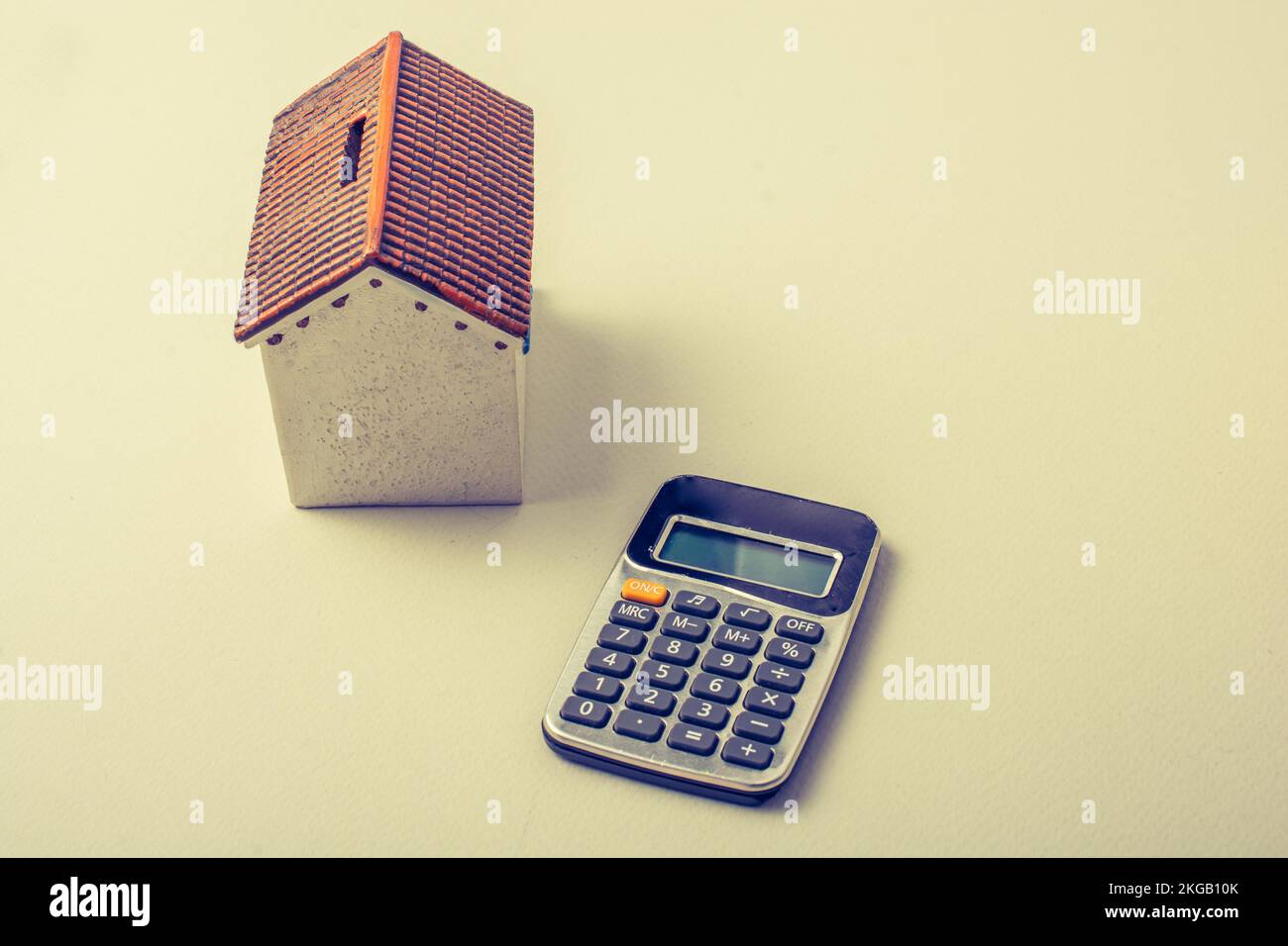 Model house and calculator placed on white background Stock Photo - Alamy