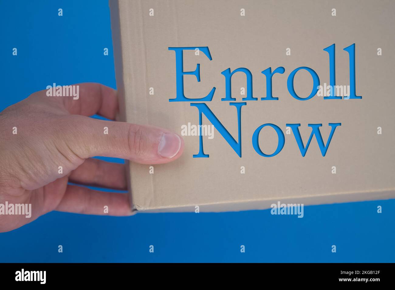 Enroll Now word with cardboard box. Brown folded card box Stock Photo ...