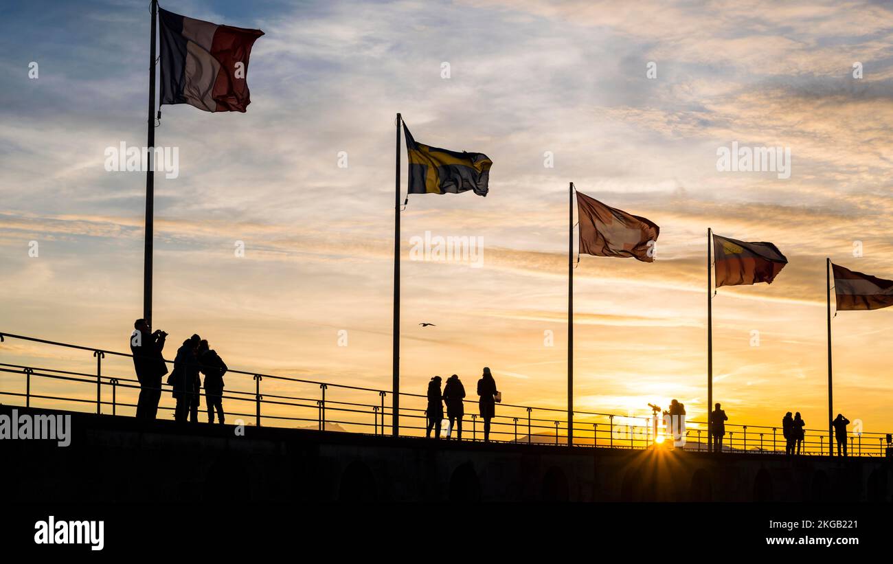 People, silhouettes, flags, harbour in Lindau am Lake Constance ...
