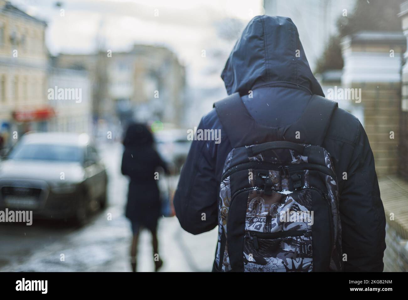 Hipster man in hood walking through city street Stock Photo - Alamy