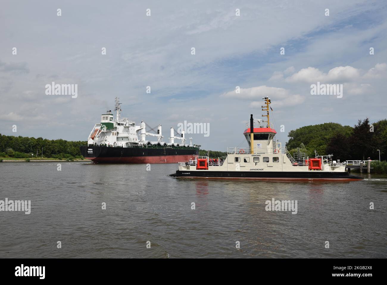 Cargo ship and car ferry on the Kiel Canal near Fischerhütte, Schleswig ...