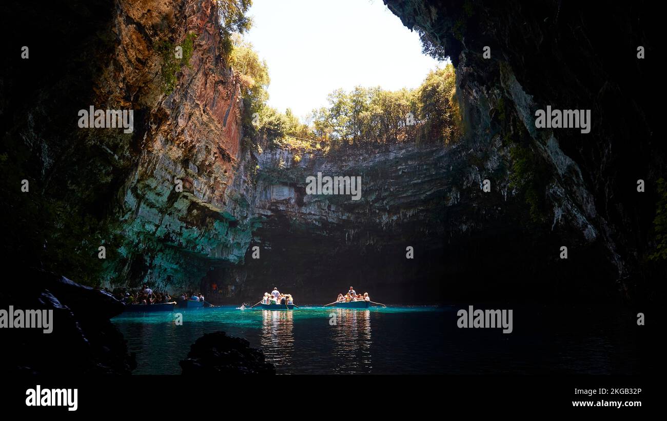 Two boats with tourists, water reflections, opening in cave ceiling ...