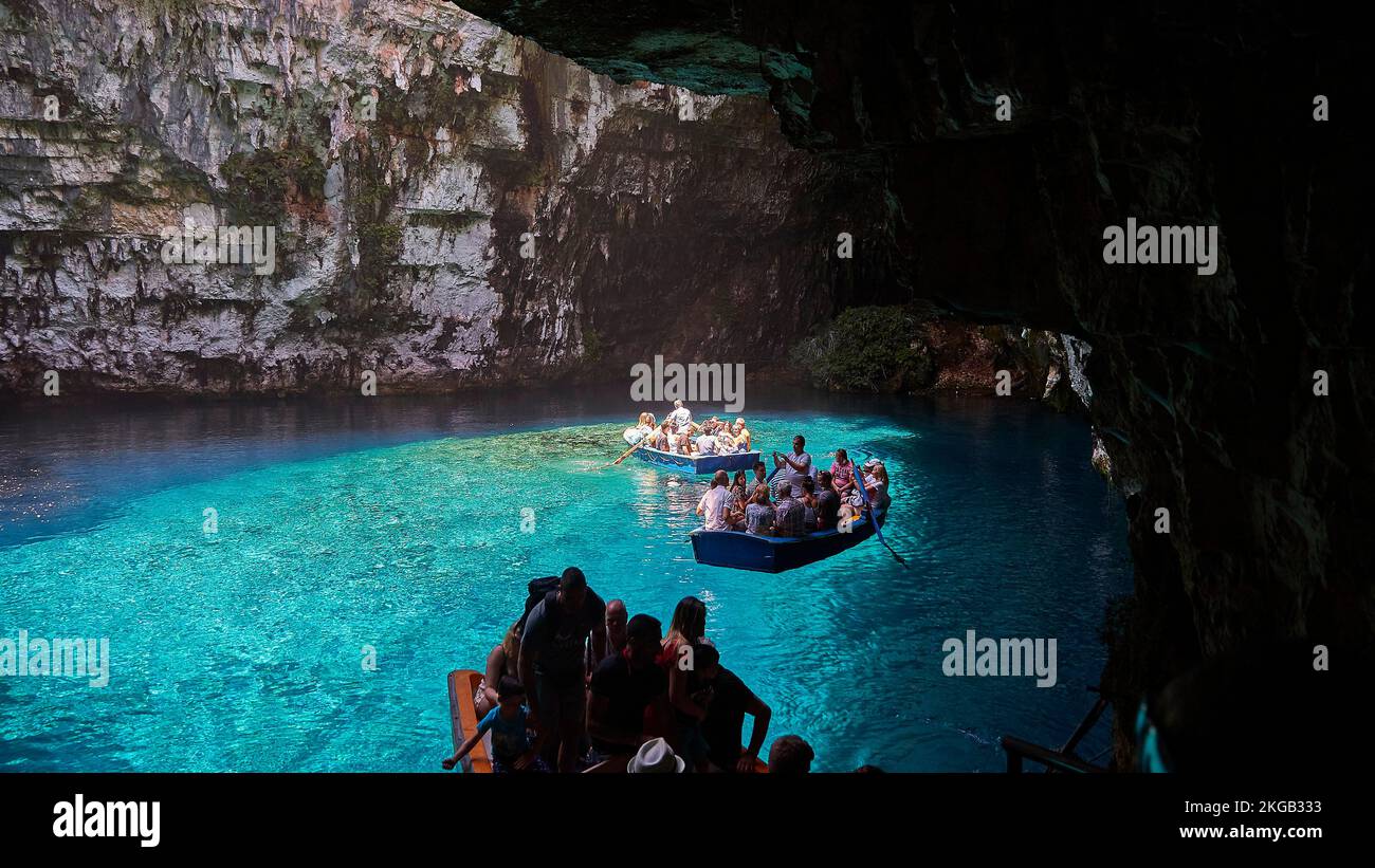 Boats with tourists, turquoise water, grey cave walls, Melissani Cave ...