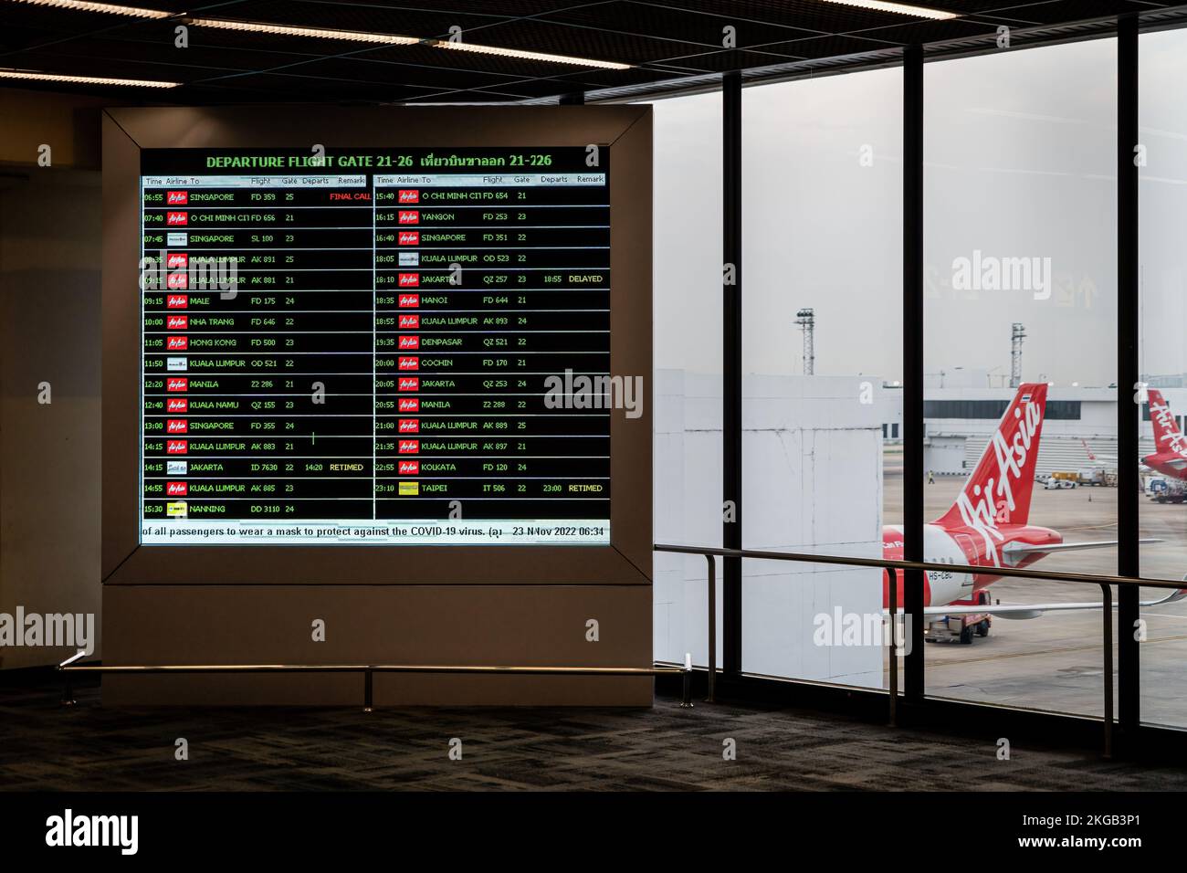 A departures time board is seen in front of parked Thai AirAsia (FD ...