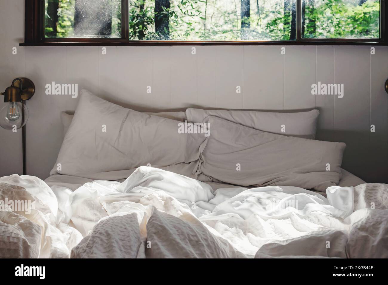 Empty bed in the morning. White bedding and pillows, cozy cabin ...