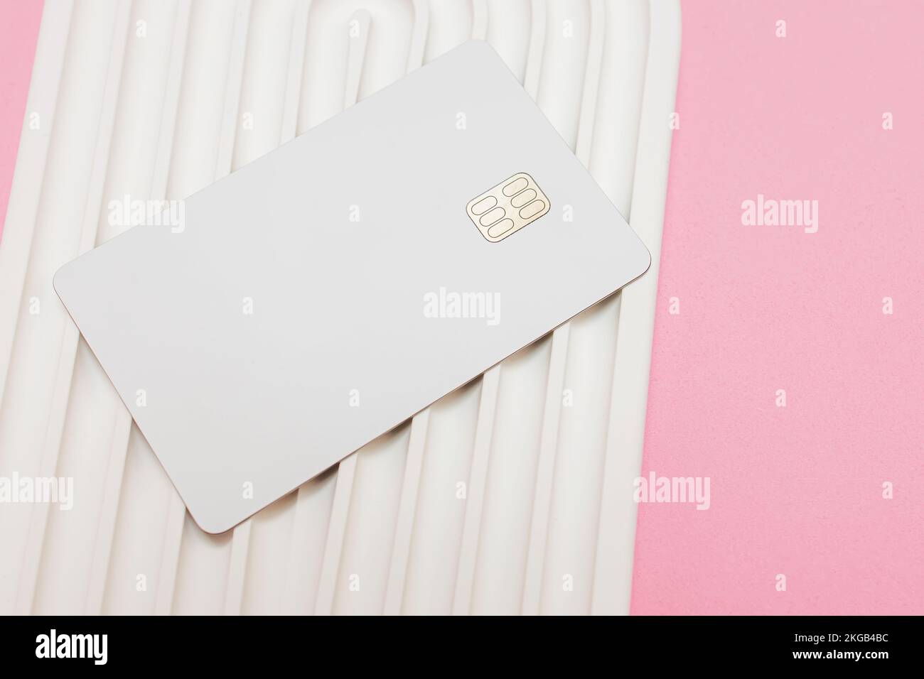 White credit or debit card with chip on the wavy white stone surface ...