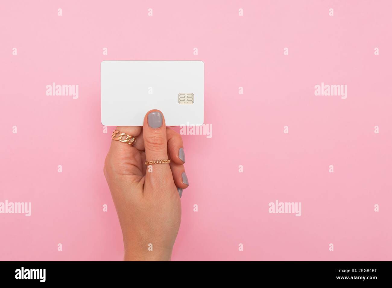 Women's hand holding white plastic credit or debit card with chip over ...