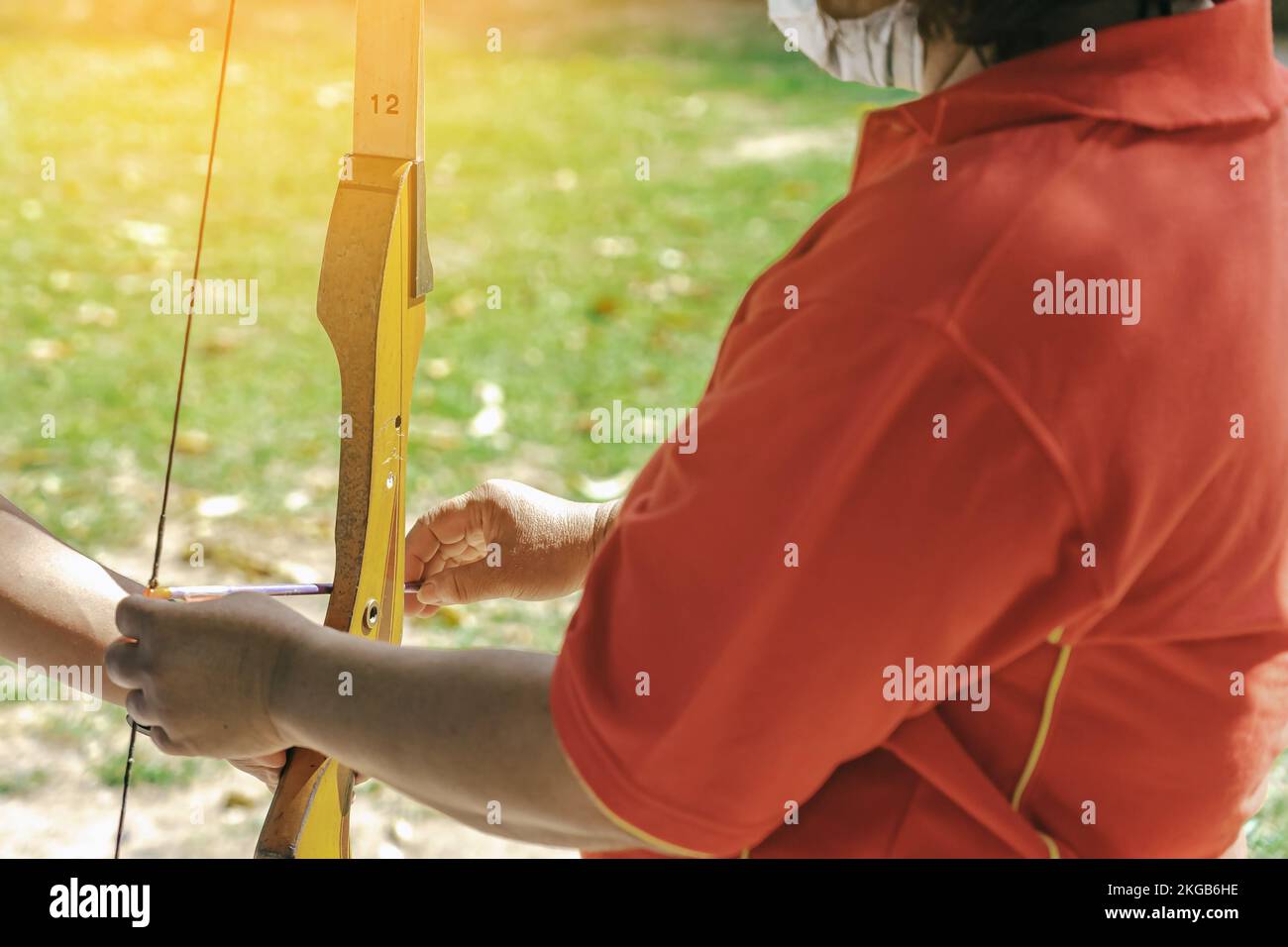 Female teacher teaches student to aim at goal. An archer teaching young ...