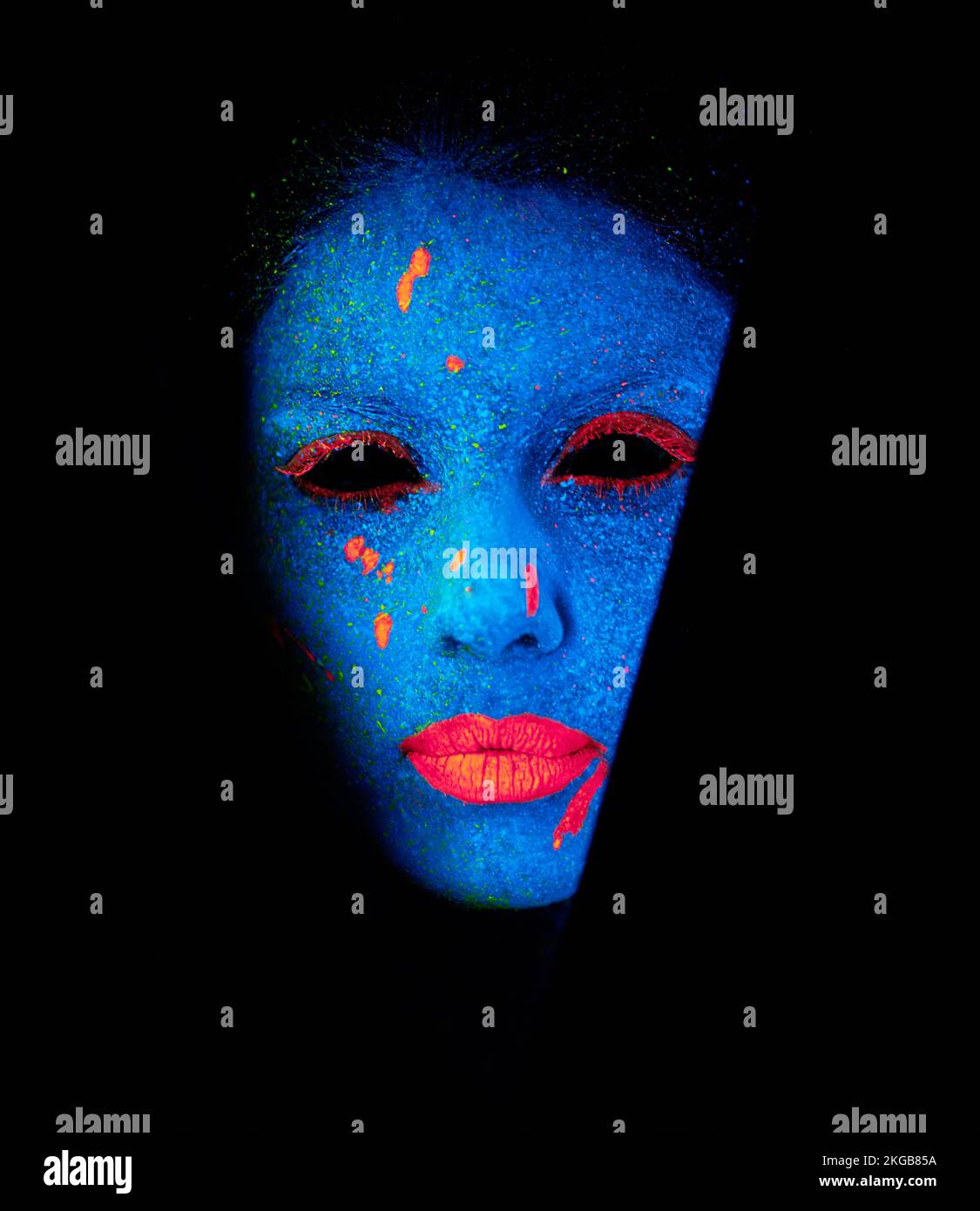Glowing beauty in the dark. a young woman posing with neon paint on her ...