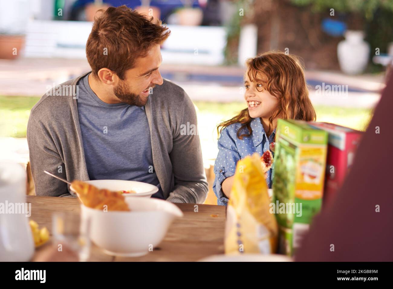 Having a hearty breakfast. a little girl eating breakfast with her dad ...