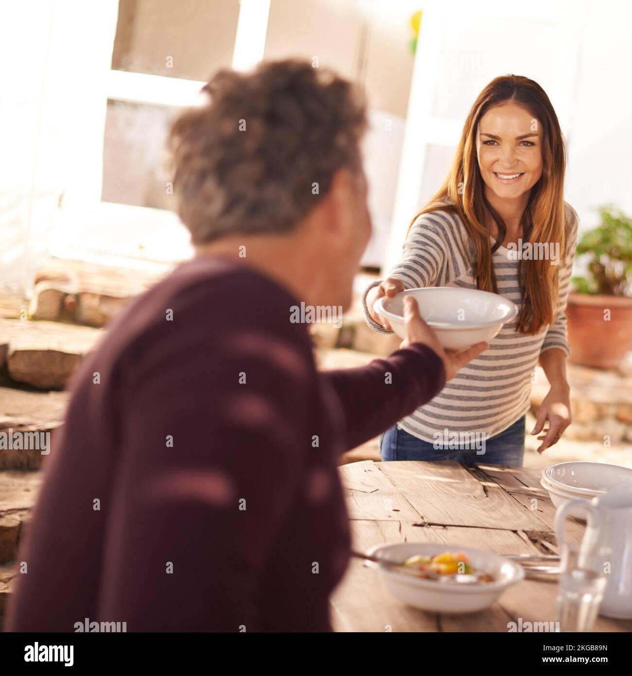 Id like some cereal please. a woman having breakfast with her senior ...