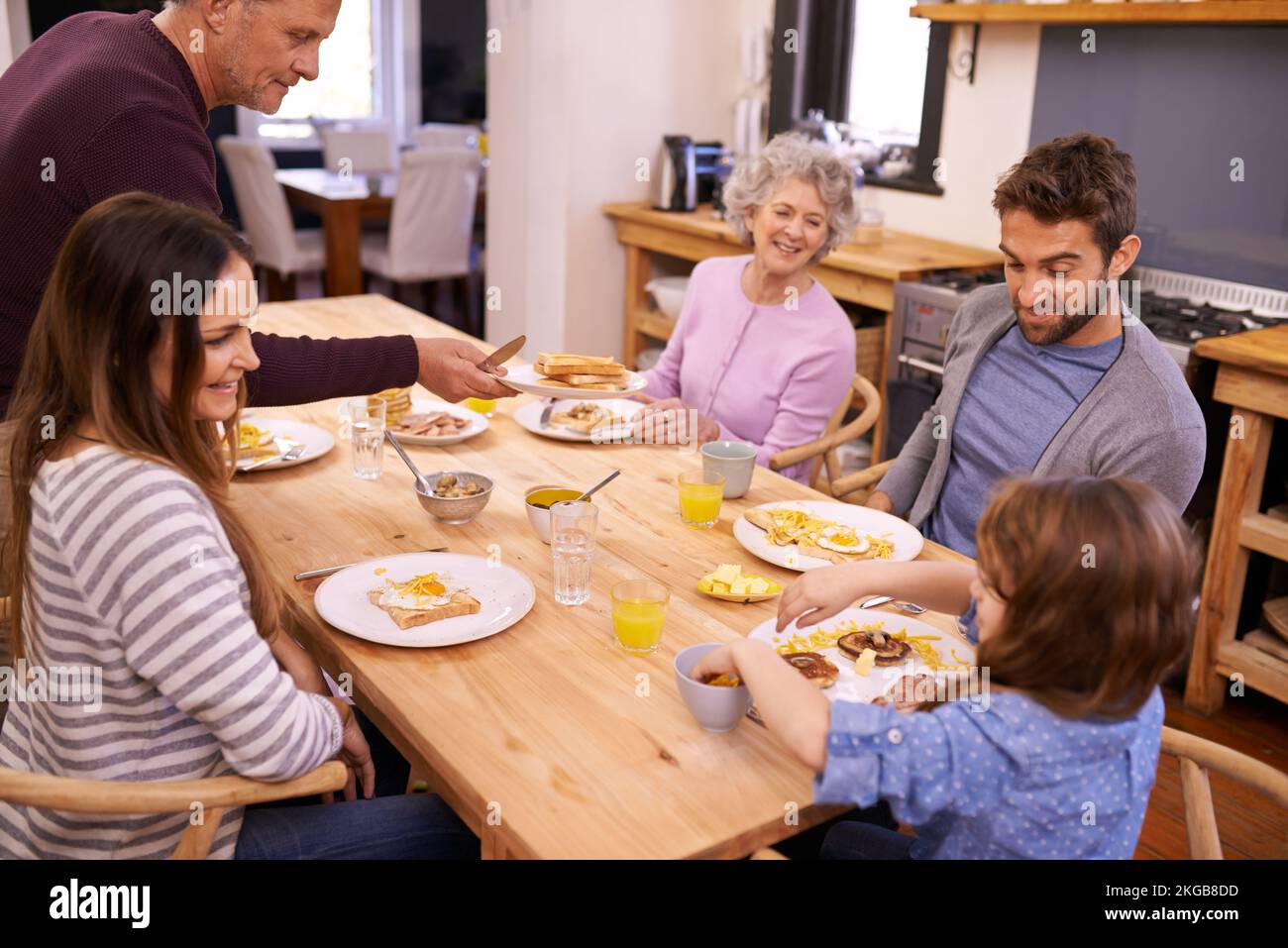Breakfast is their favorite meal of the day. a family eating breakfast ...