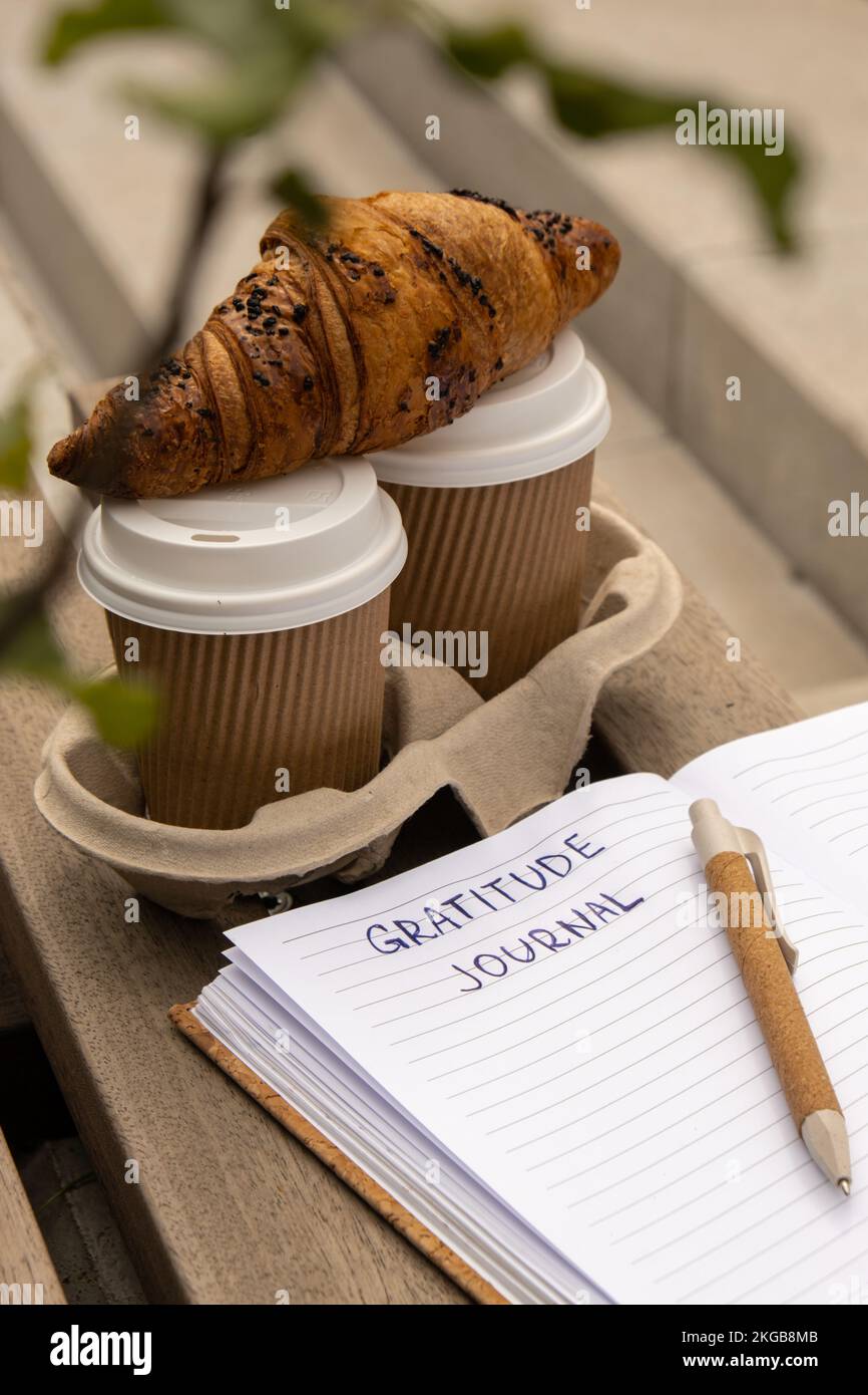 Writing Gratitude Journal on wooden bench. Coffee and croissants ...