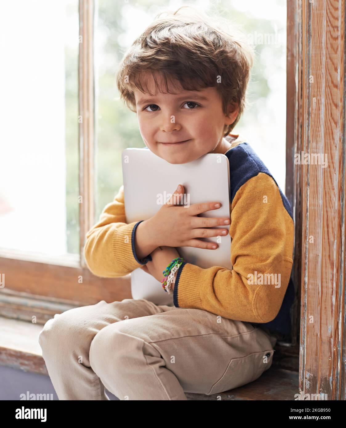 Hes tech savvy already. a cute little boy using a tablet while sitting ...