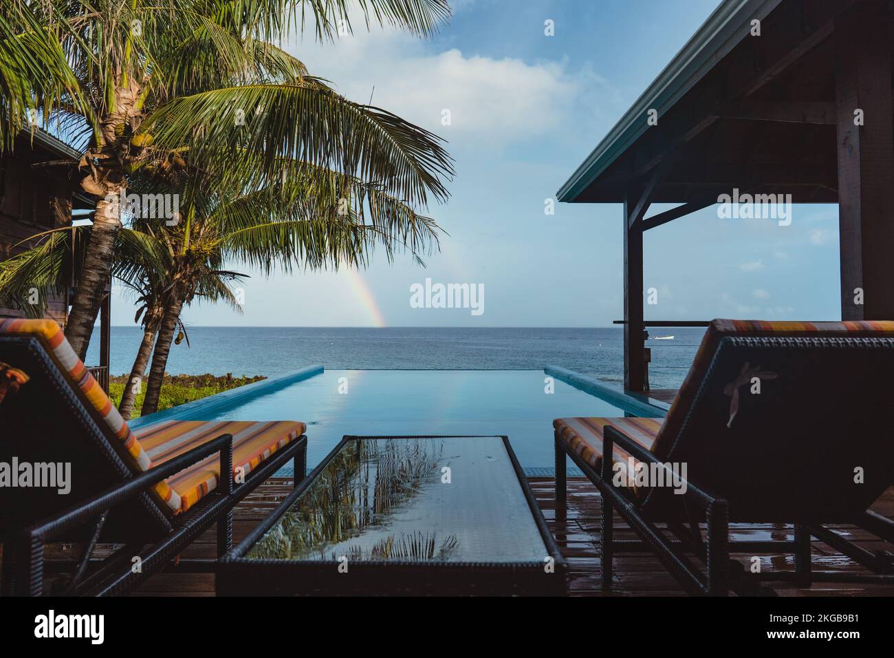 A beautiful view of rainbow over ocean seen from a pool deck in Roatan ...