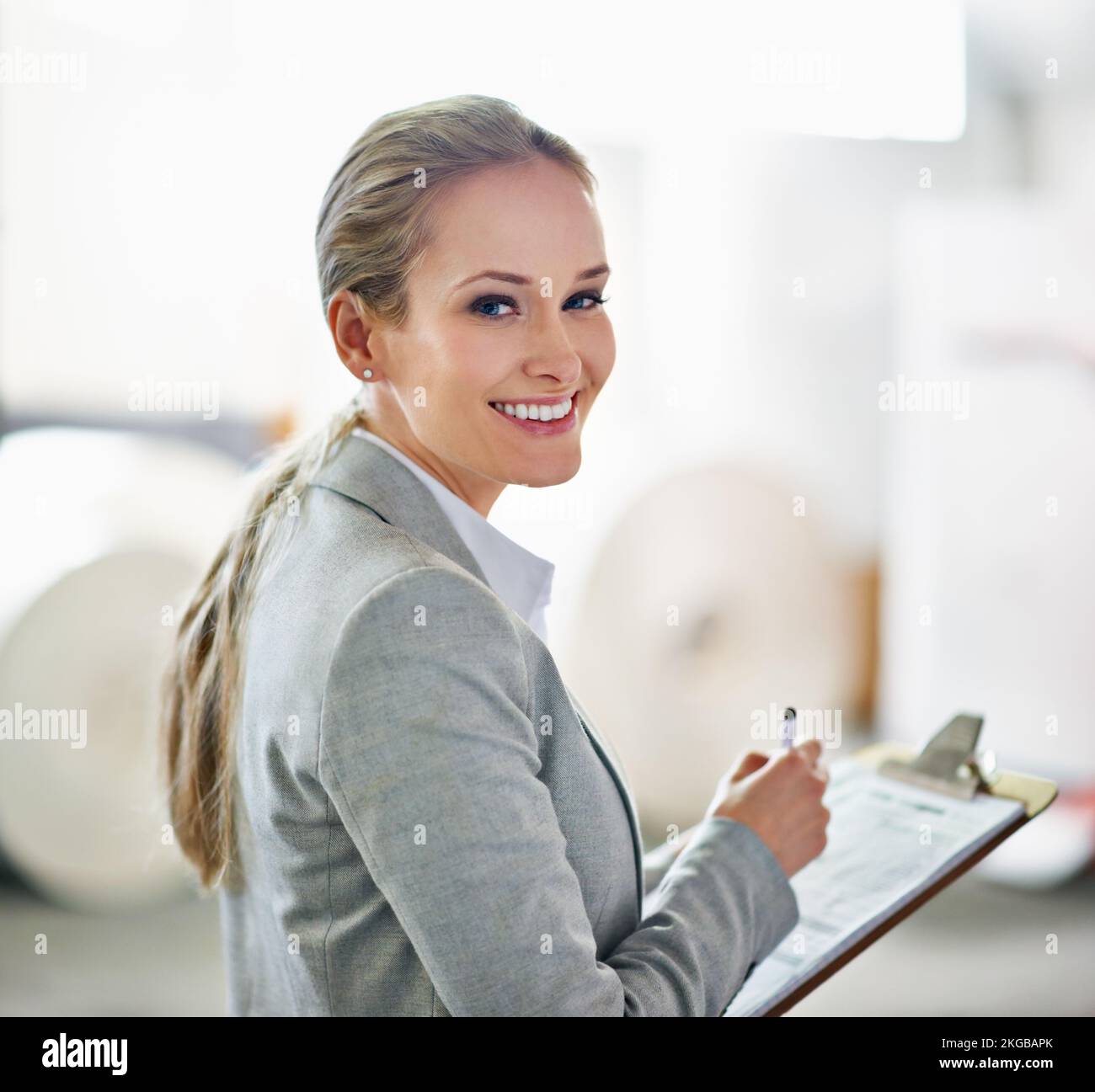 Checking the numbers. Portrait of a woman holding a clipboard in a ...