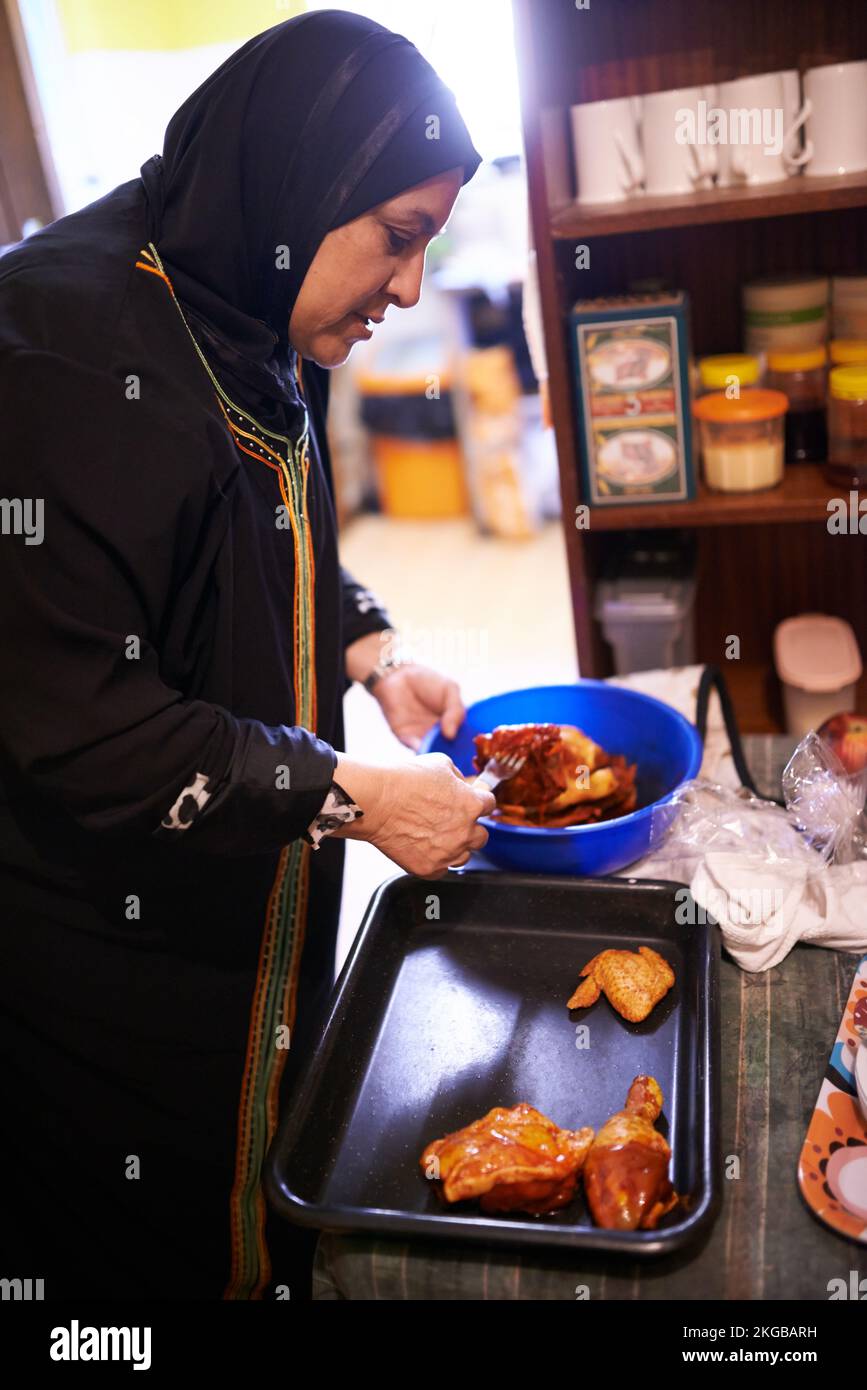 Cooking up something special. a muslim woman preparing food Stock Photo ...
