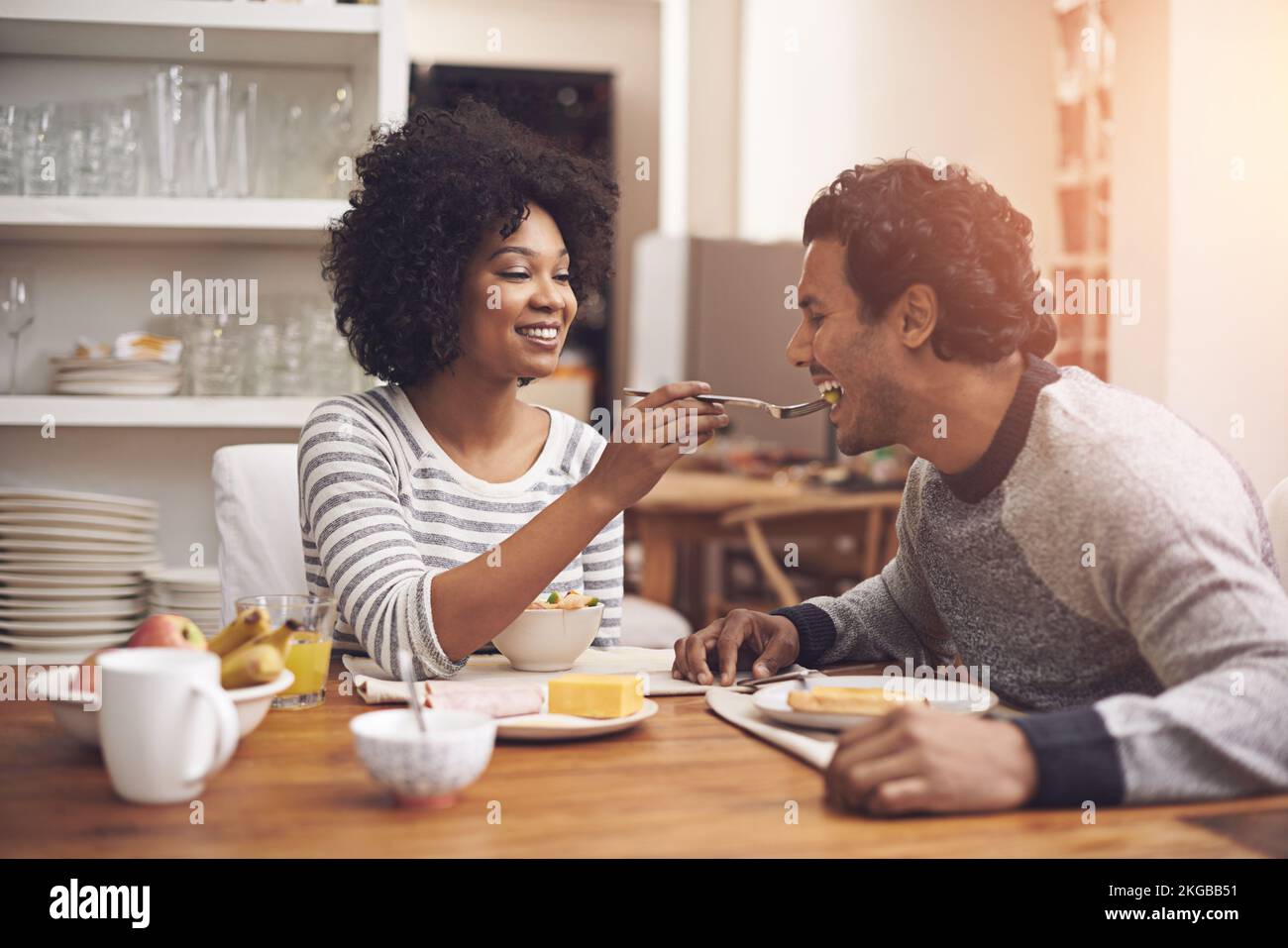 Breakfast affections. a couple eating breakfast together at home Stock ...