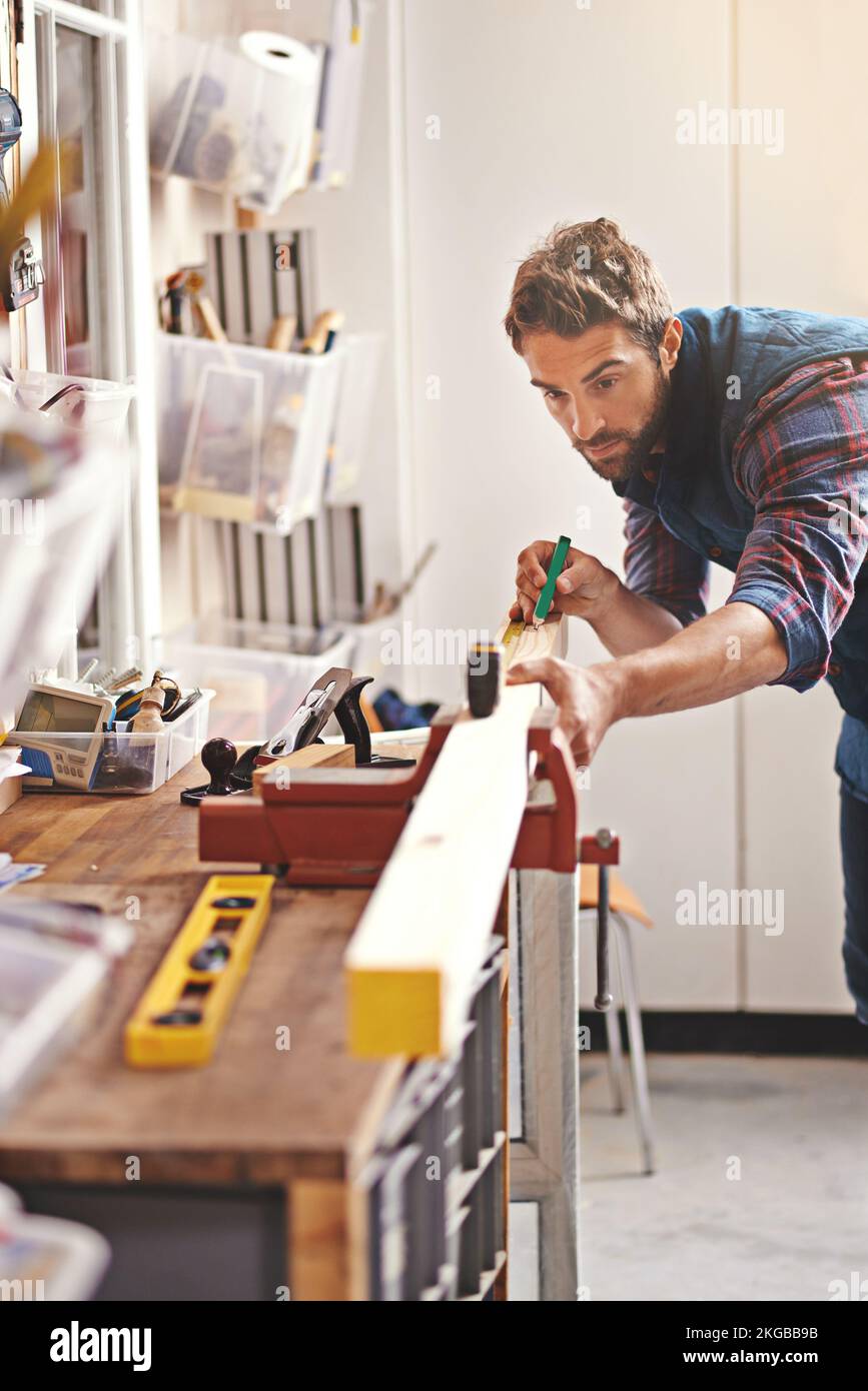 Hes a woodworking master. a carpenter making measurements on a plank of ...
