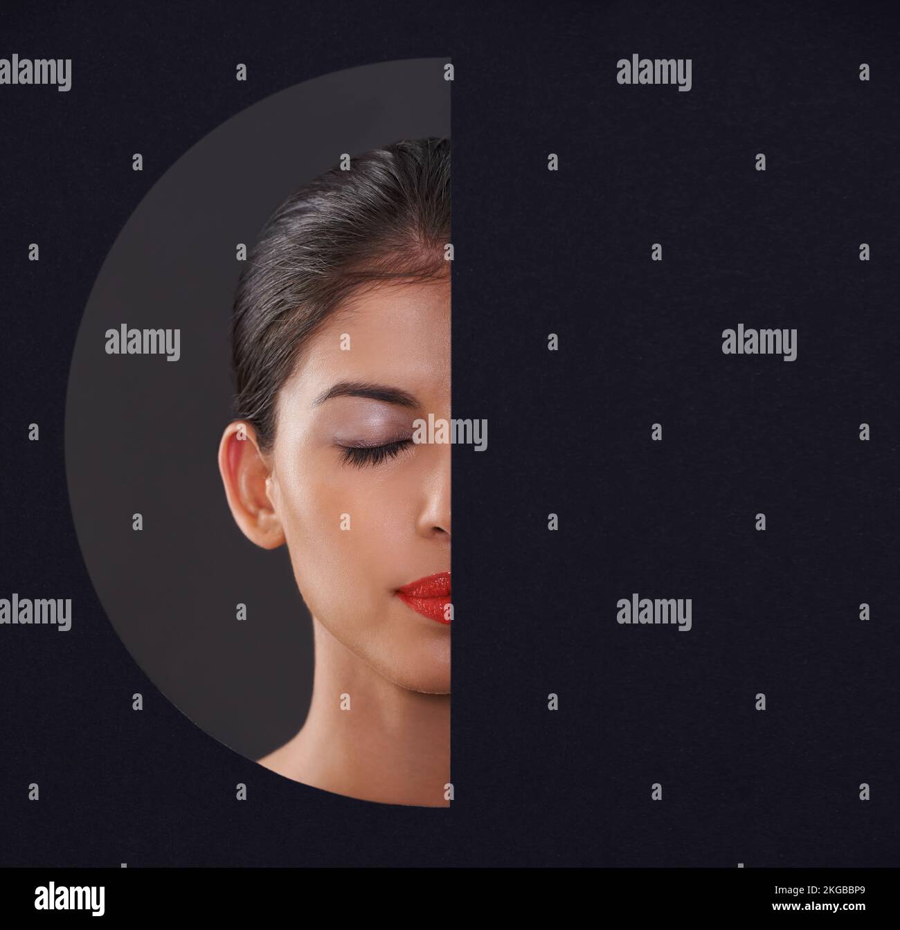 Revealing her best side. a beautiful young woman through a cut out ...