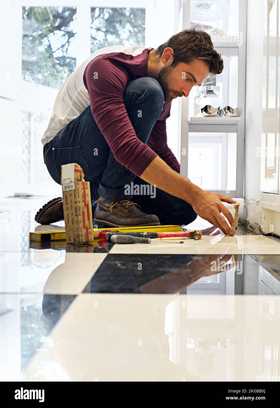 Young guy laying tiles hi-res stock photography and images - Alamy