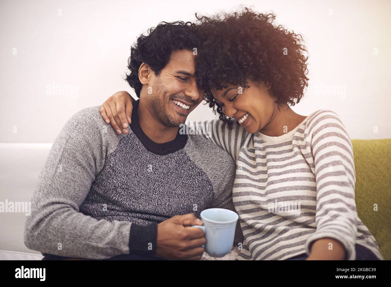 Live. Love. Laugh. an affectionate couple relaxing on the sofa at home ...