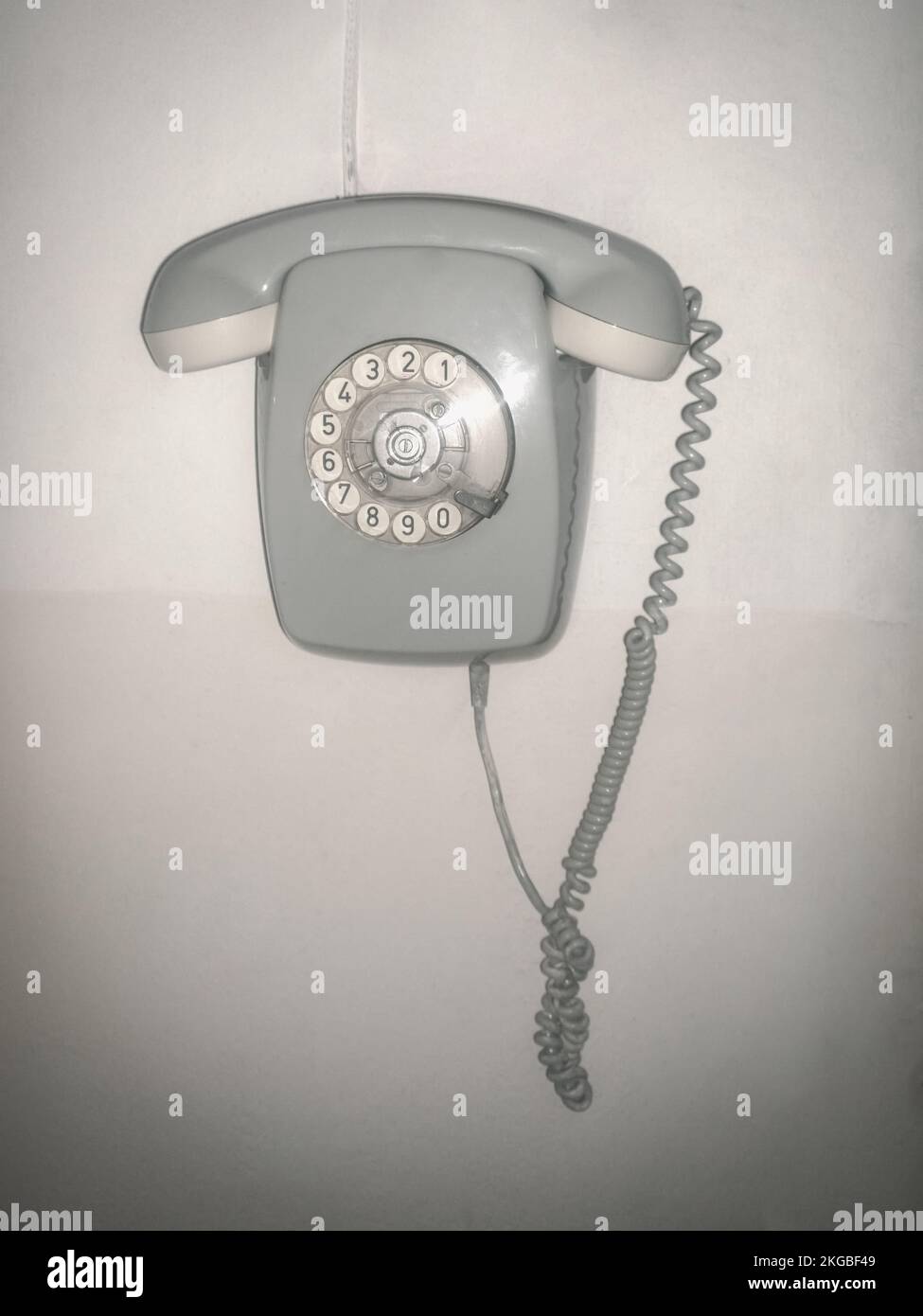 Retro rotary dial phone hanging on the wall Stock Photo - Alamy